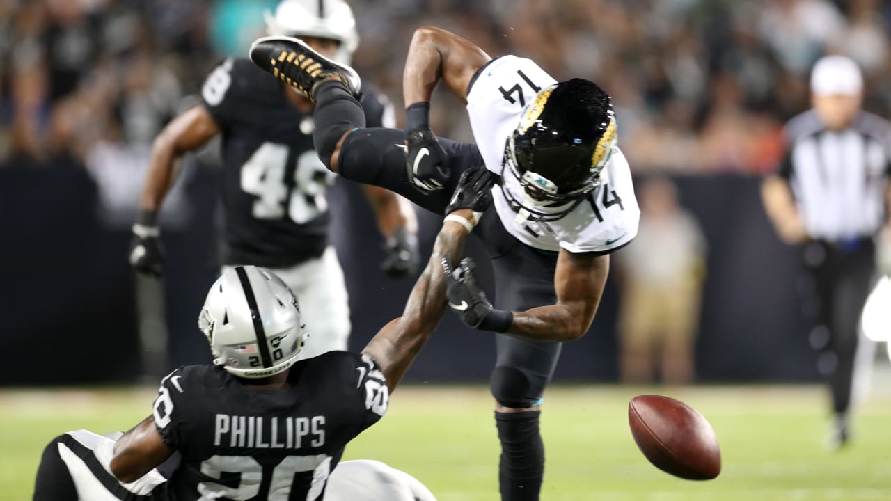 Las Vegas Raiders safety Duron Harmon jars the football loose from Jacksonville Jaguars wide ...
